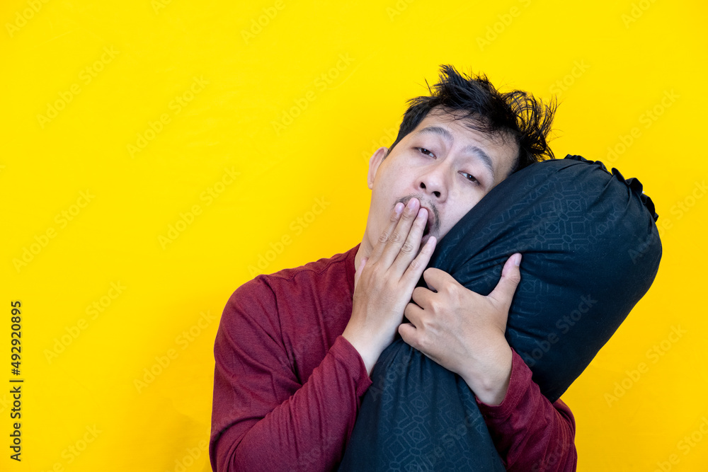 Cute asian man hugging bolster and sleepy expression, waking up. Stock ...