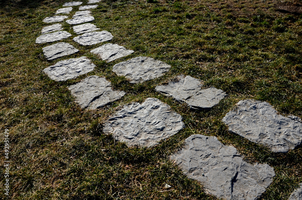 gray stone in a garden with a stone nature path to the arches near the ...