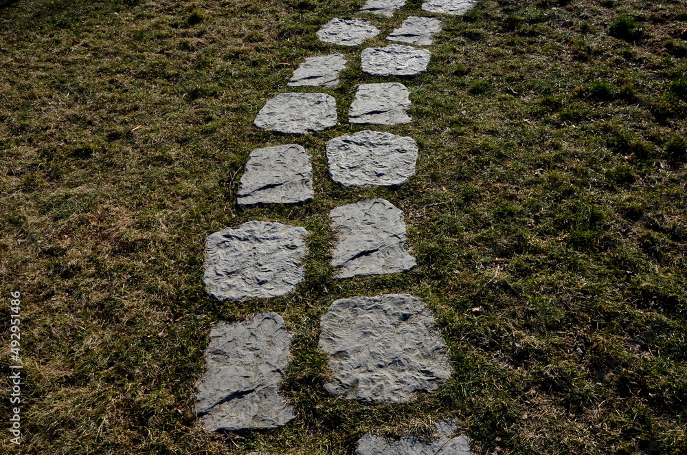 gray stone in a garden with a stone nature path to the arches near the ...