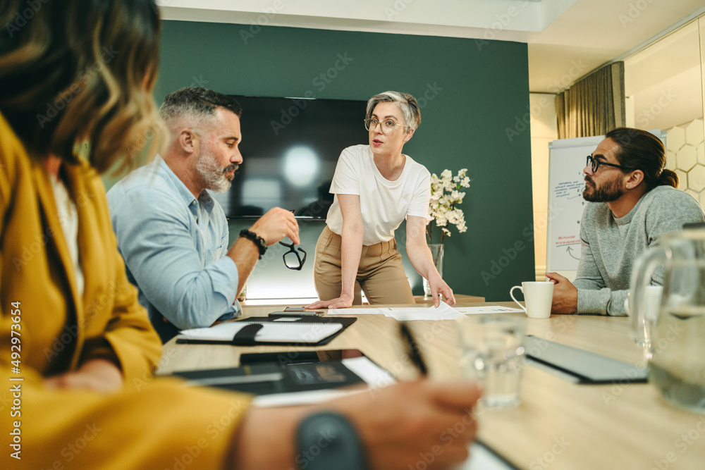 Business manager leading a meeting with her team in a boardroom Stock ...