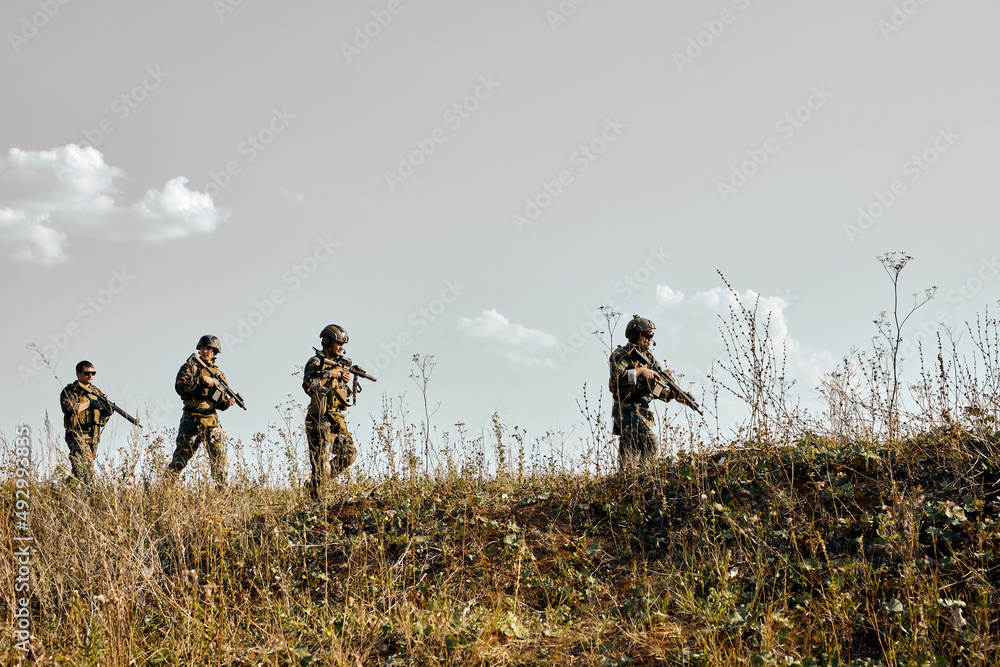 Armed special forces soldiers with rifle going against enemies, in row ...