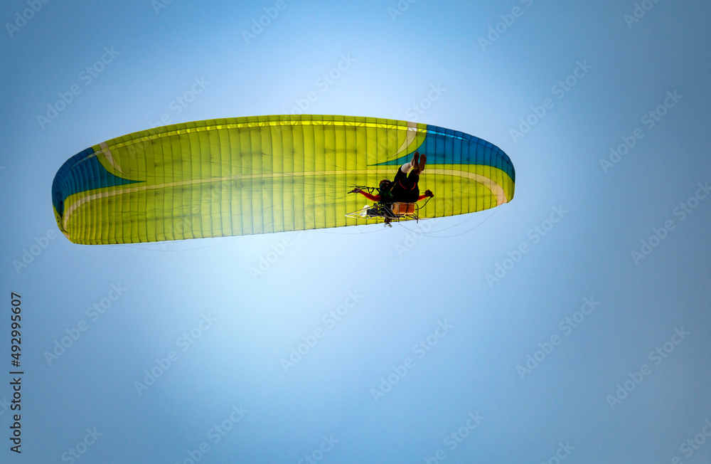 Paramotor Flying through sunlight with Blue Sky.Adventure man active ...