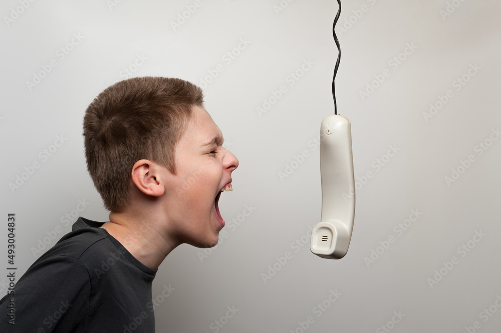 emotional boy screaming into a hanging telephone receiver Stock Photo ...
