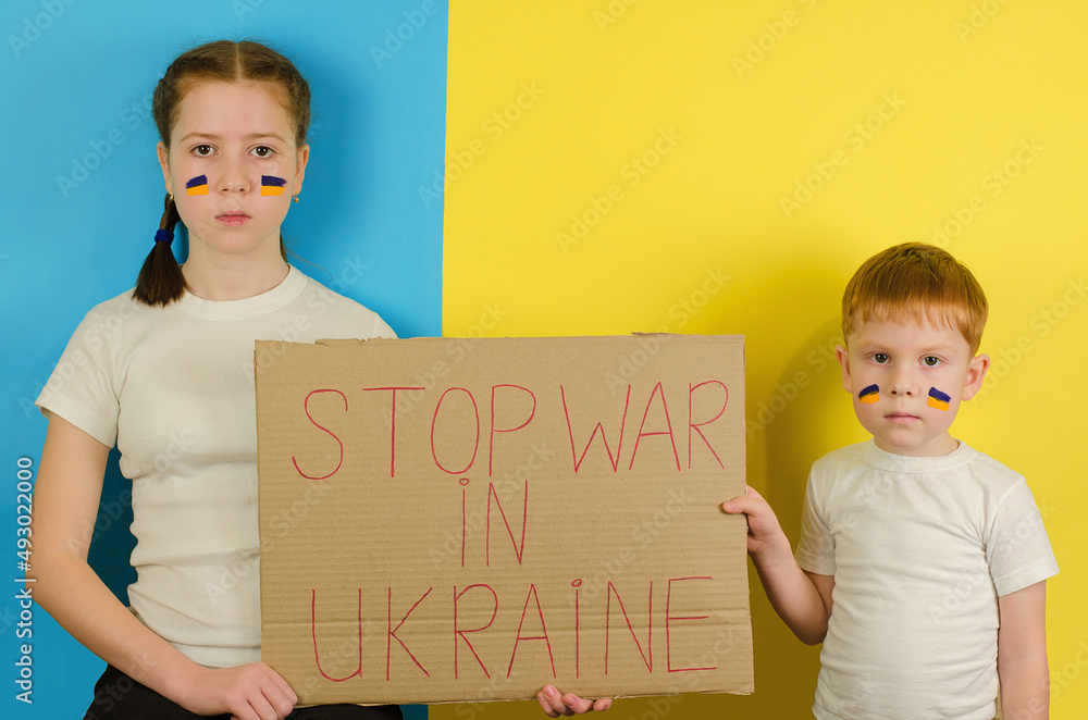 Sad Ukrainian children stand against the background of the Ukrainian ...