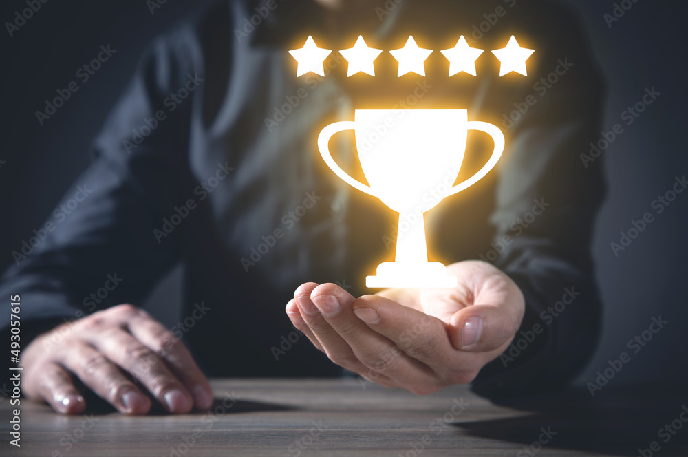 Man holding winner trophy cup and five stars. Stock Photo | Adobe Stock