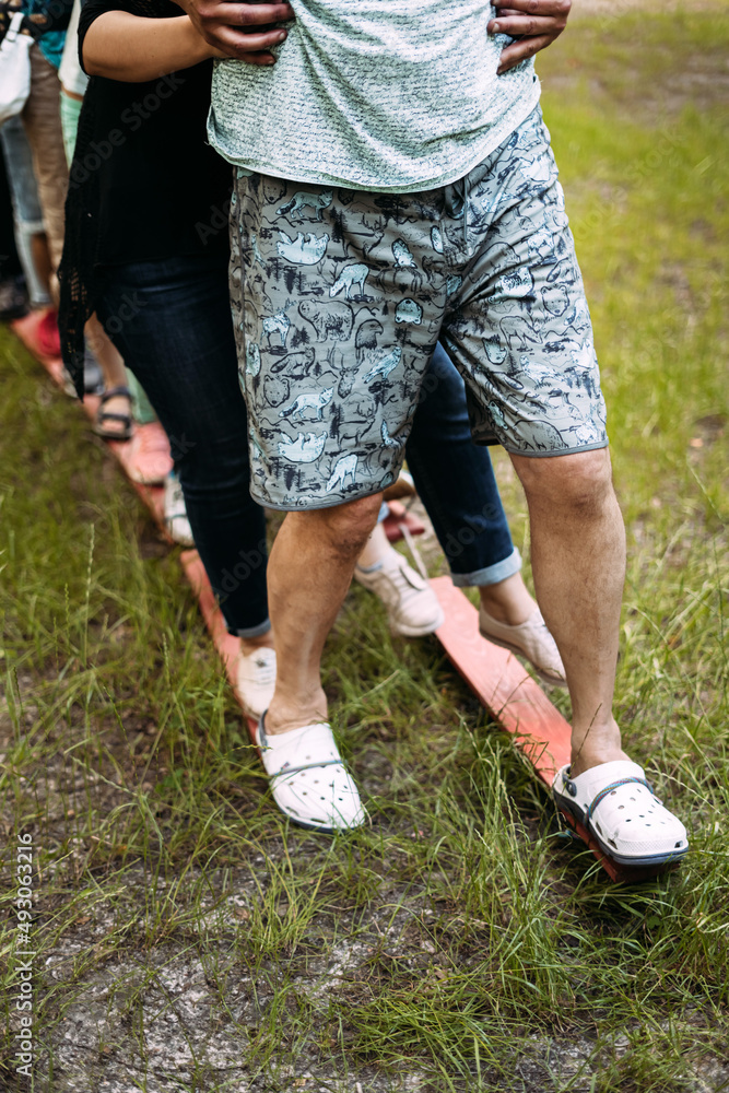 People with their feet tied together doing a team building exercise ...