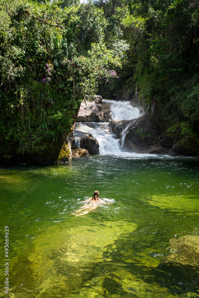 Beautiful view to woman swimming on green pool on rainforest waterfall ...