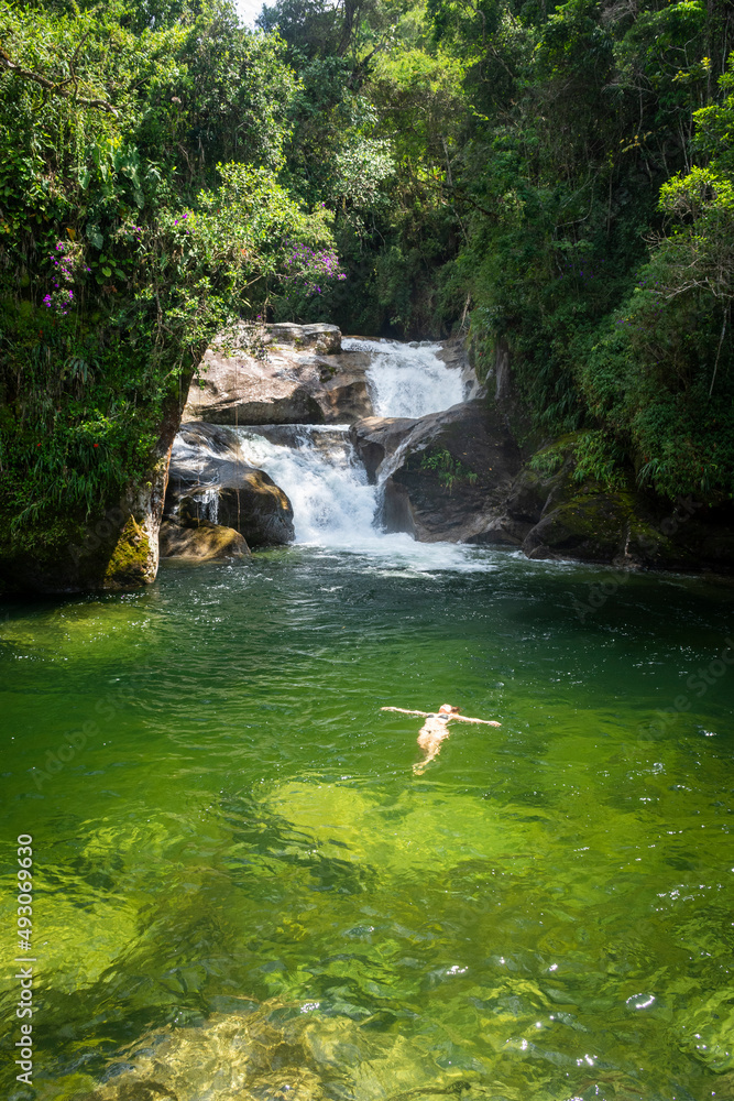 Beautiful view to woman swimming on green pool on rainforest waterfall ...