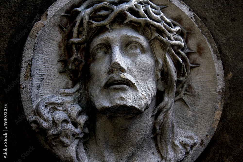 Antique stone statue of Jesus Christ in a crown of thorns as symbol of ...