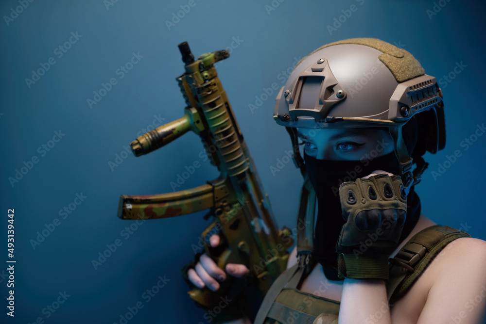girl soldier in a bulletproof vest and helmet, armed with an automatic ...