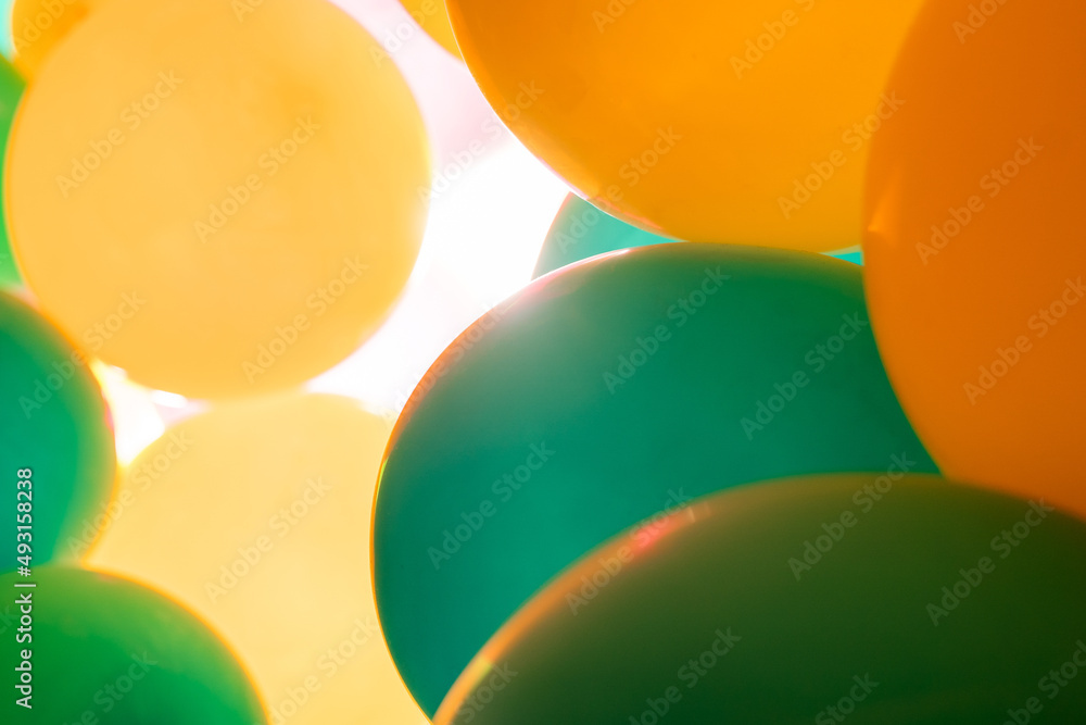 Colorful balloons all over the frame, lying one next to the other. Many ...