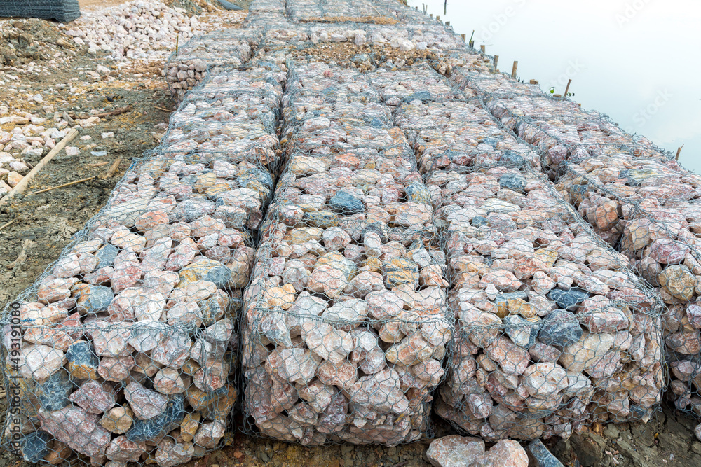 Stone walls, protection from backshore erosion. Stones in a metal mesh ...