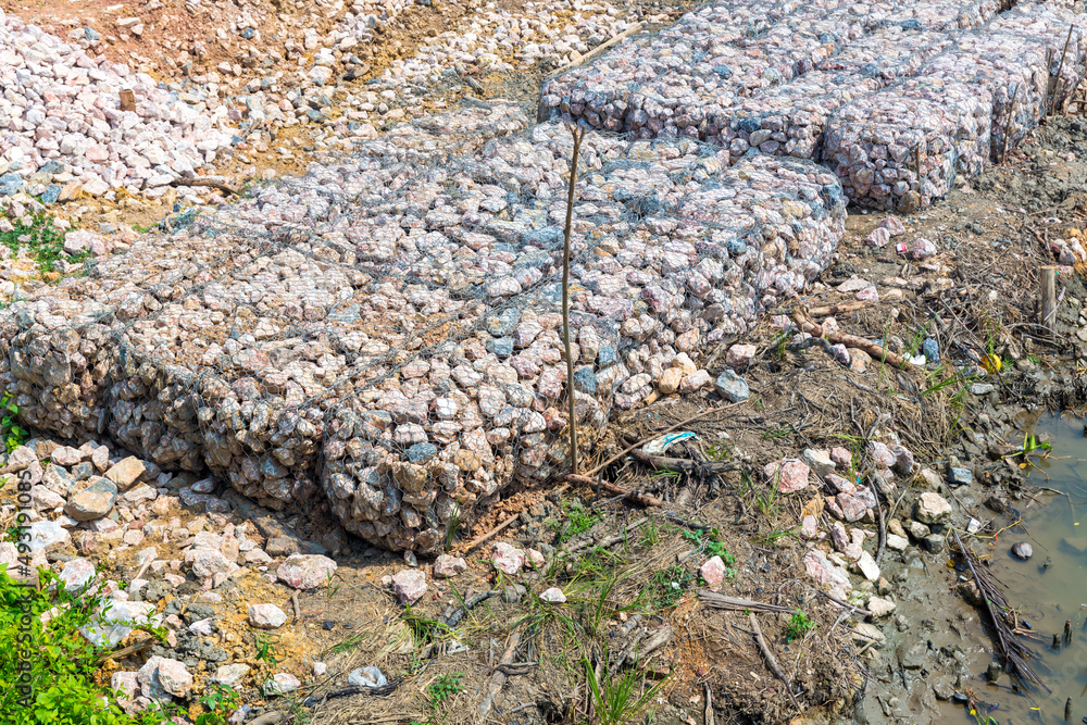 Stone walls, protection from backshore erosion. Stones in a metal mesh ...