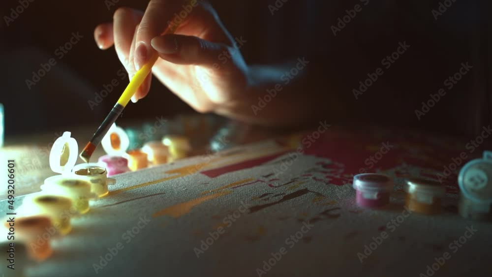 person hand drawing picture with painting by numbers with brush ...