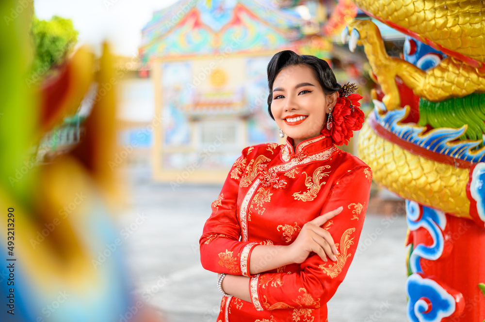 Asian beautiful woman wearing a cheongsam poses at shrine on Chinese ...