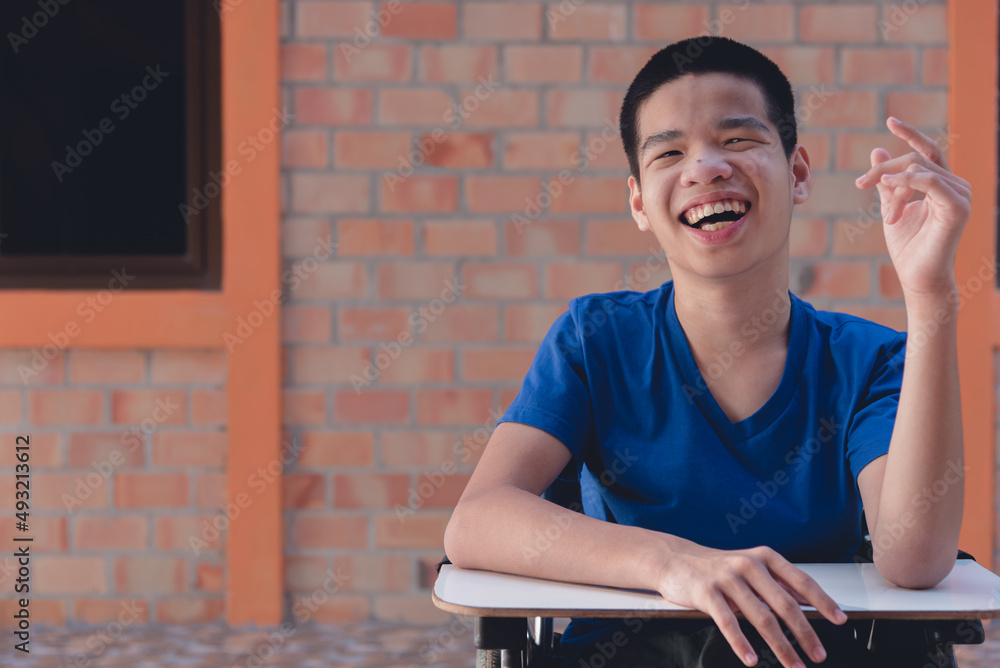 Young man with disability with happy face on orange brick wall ...