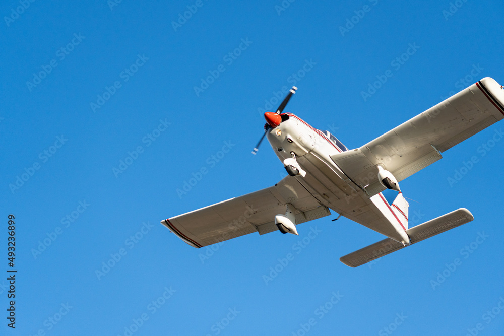 Foto de Small plane flying in a clear blue sky turning to land do Stock ...