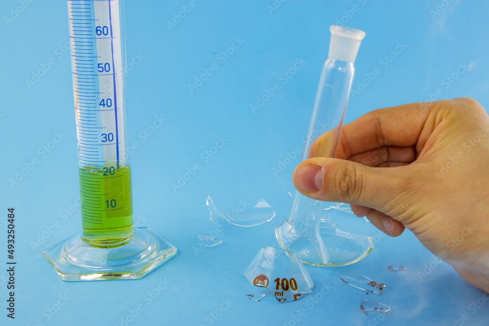 Laboratory experiment. Hand holding broken lab flask glass and ...