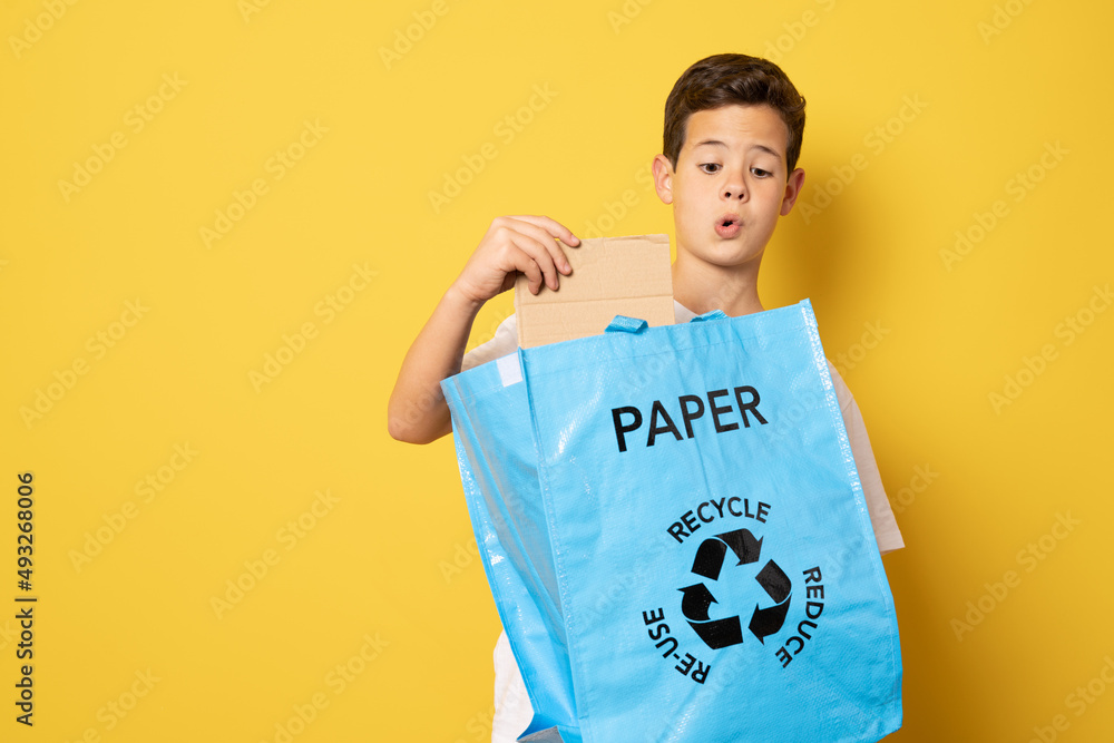 Child boy holding and sorting of paper in the recycling box for ...