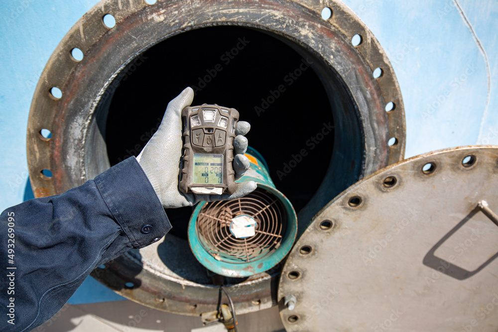 Worker hand holding gas detector inspection safety gas testing at front ...