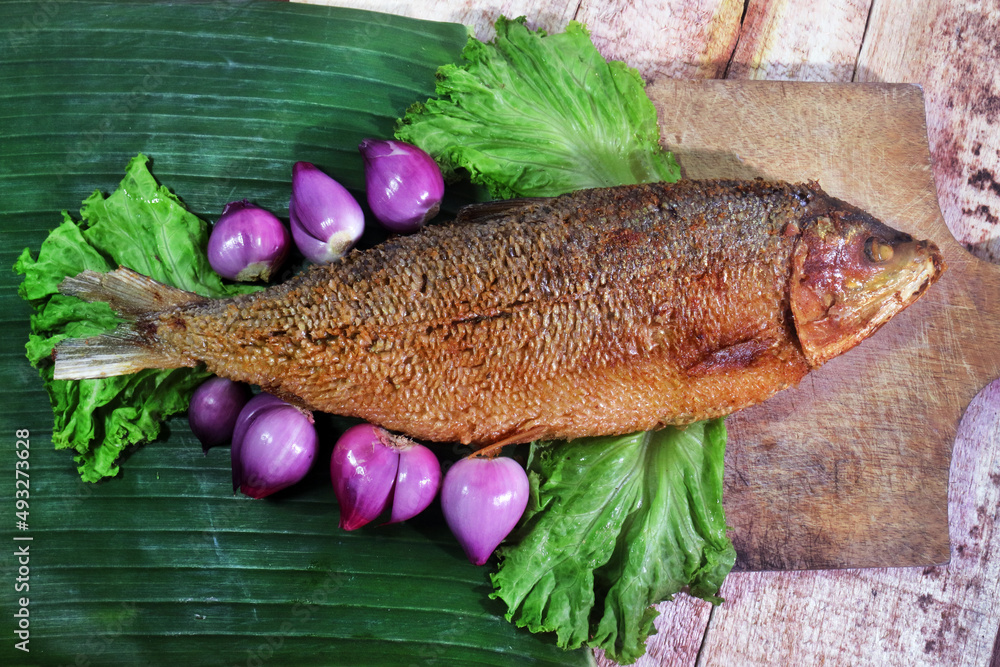Bandeng Presto Fried Milkfish concept on the banana leaf with Shallot ...