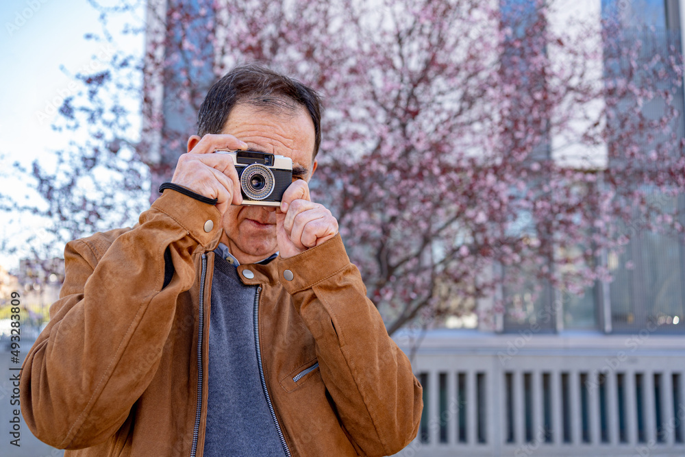 Older man is photographed while shooting with his old film camera ...