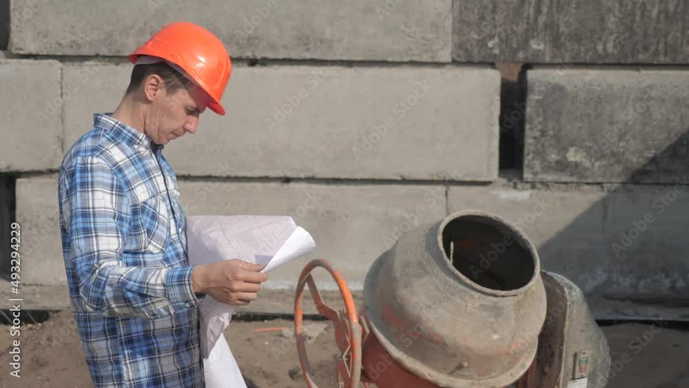 male architect a builds foundation of cement and concrete mixer ...
