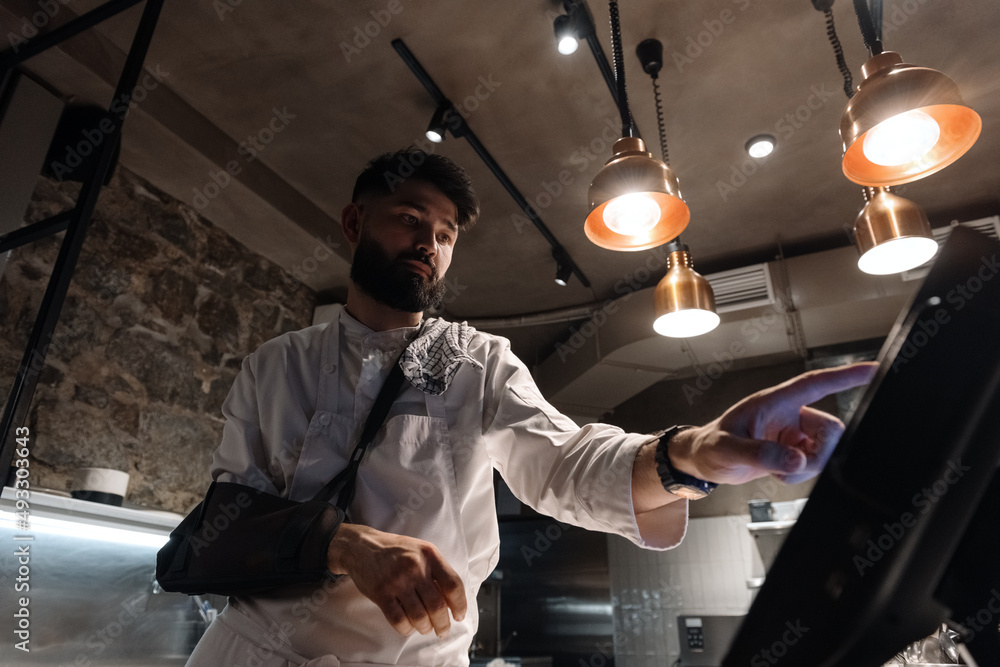 Male chef confirming order on computer Stock Photo | Adobe Stock