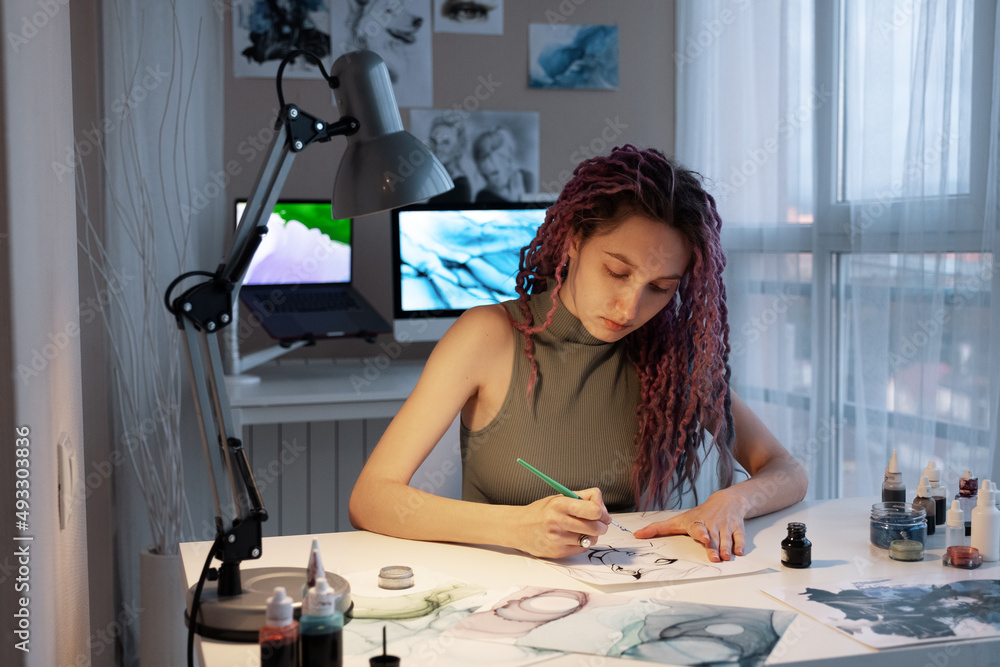 Young female illustrator drawing picture with ink Stock Photo | Adobe Stock