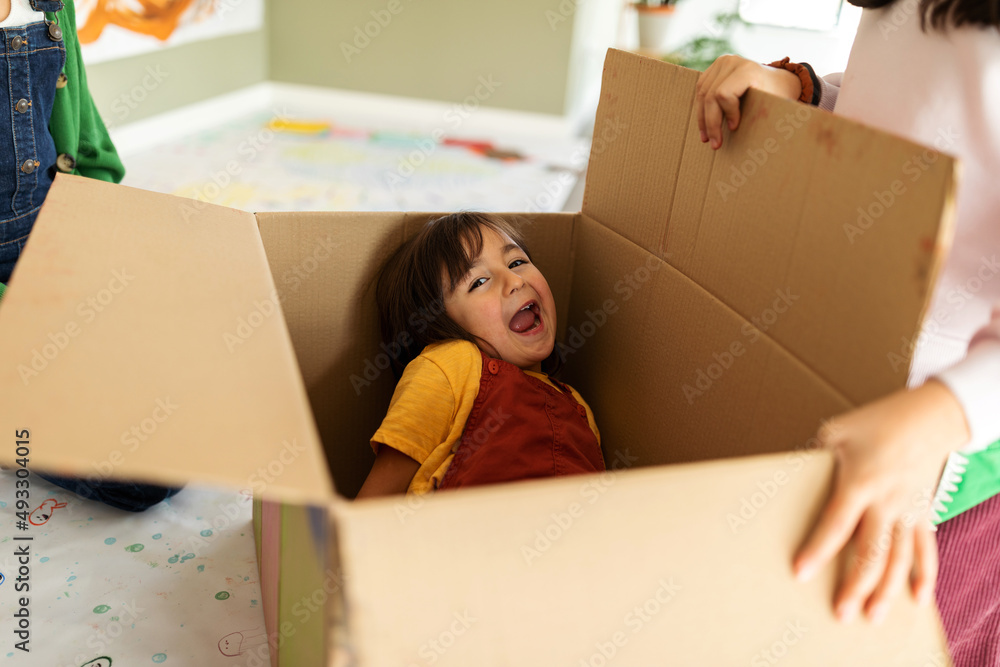Funny little girl inside a cardboard box Stock Photo | Adobe Stock