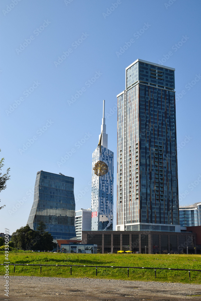 Details of a modern skyscraper building with small ferris wheel in ...