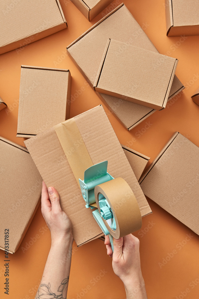 Woman packing boxes for delivery with scotch Stock Photo | Adobe Stock