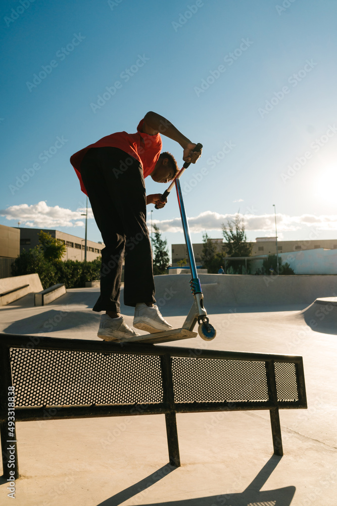 Colombian teen male riding scooter on railing in park Stock Photo ...