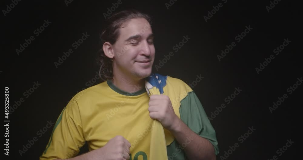Young brazilian man, soccer fan, dancing, partying, enjoying, swinging ...