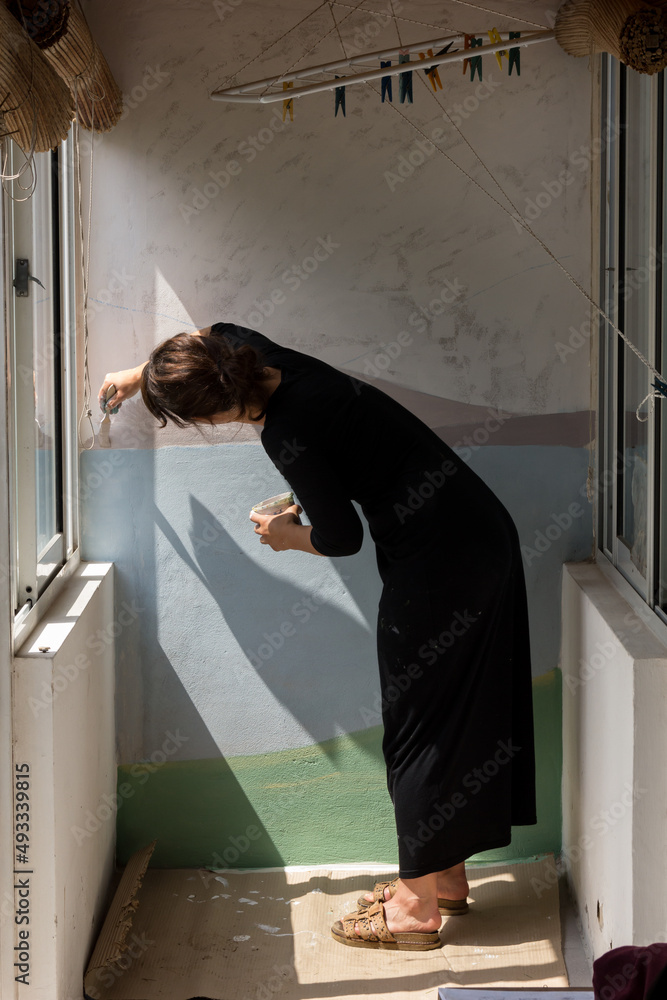 Mujer pintando un mural con una brocha. Hermosa Artista pinta con un ...