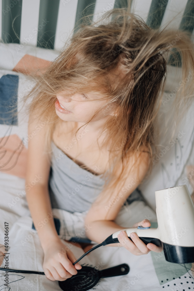 Little girl drying her hair Stock Photo | Adobe Stock