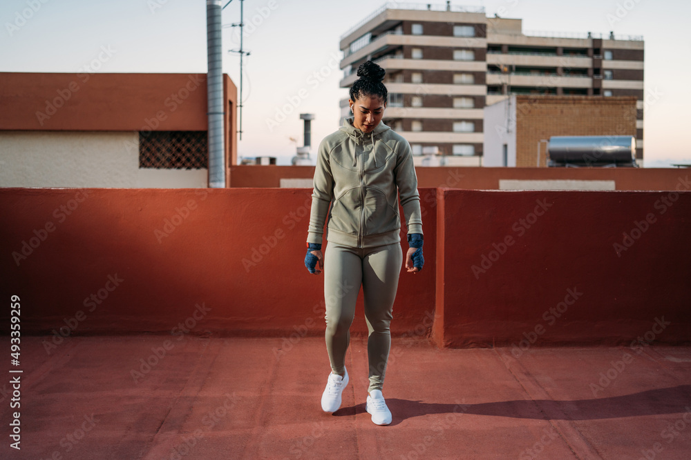 Tired female fighter on rooftop Stock Photo | Adobe Stock