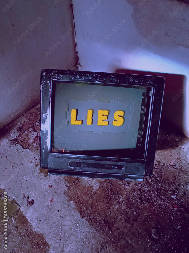 Old TV in a corner displaying LIES message Stock Photo | Adobe Stock