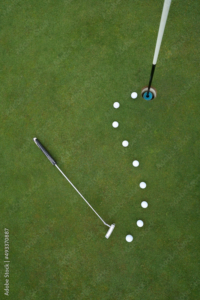 Putting green with line of golf balls and putter Stock Photo | Adobe Stock