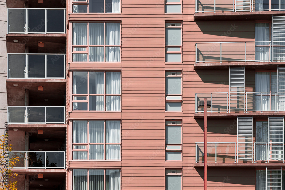 Pink wooden building with glass windows and balconies Stock Photo ...