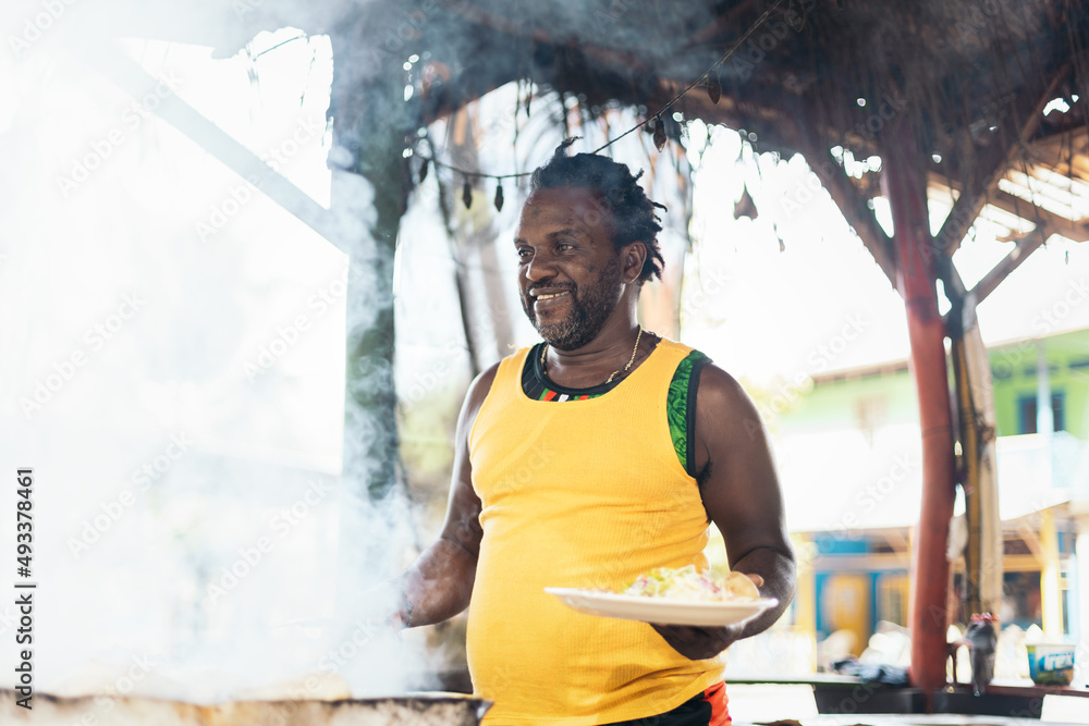 Afro-Caribbean man cooking on a barbeque Stock Photo | Adobe Stock