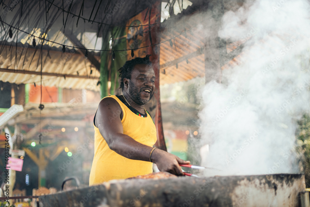 Afro-Caribbean man cooking on a barbeque Stock Photo | Adobe Stock