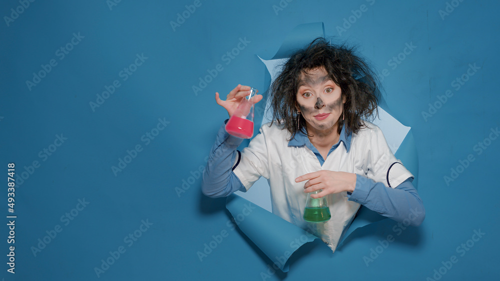 Foolish crazy chemist doing silly grimace and holding beakers after ...