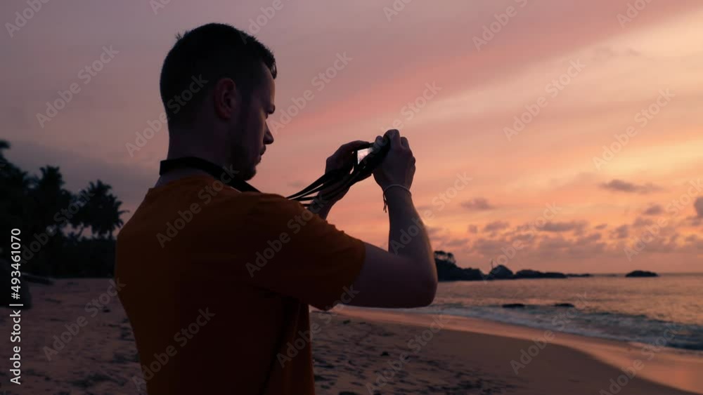 Side view of man during photographing on beach. Photographer on beach ...