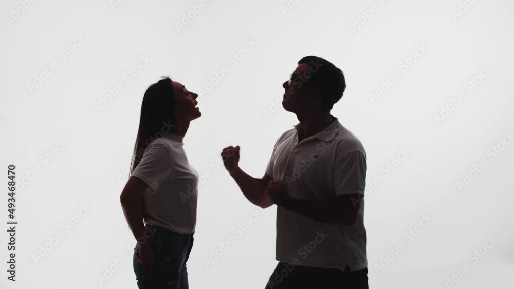 Silhouette of man who threatens woman that will hit her, she stands ...