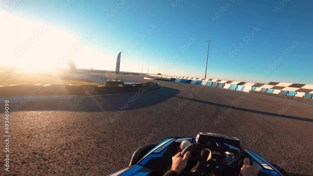 Point of view man driving a kart outdoor at sunset. Racers driving ...