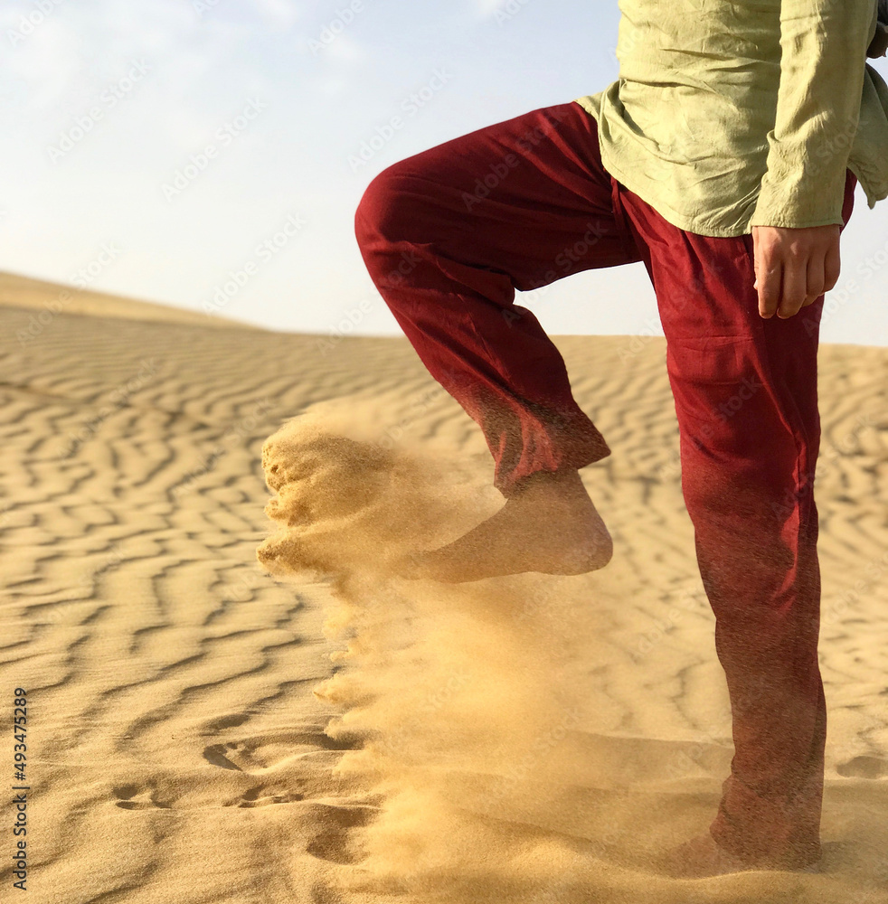 sand falling away from a feet in thar desert in india, golden colour ...