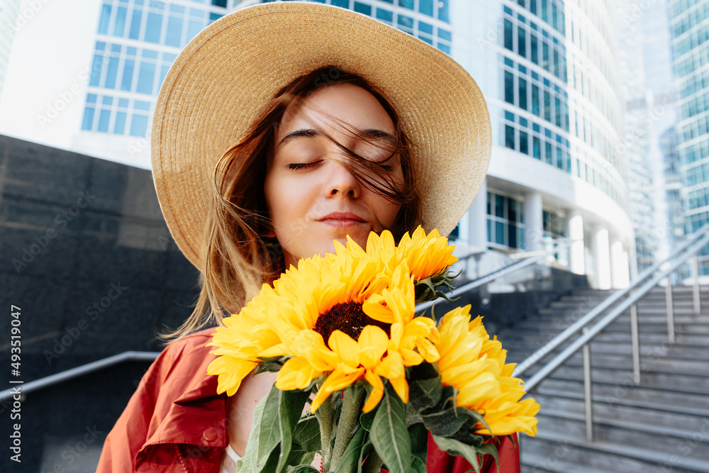 Beautiful girl is smelling a bouquet of flowers of sunflowers. Hair ...