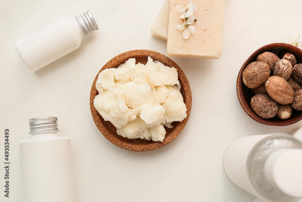 Bowl of shea butter, nuts and cosmetics on light background Stock Photo ...