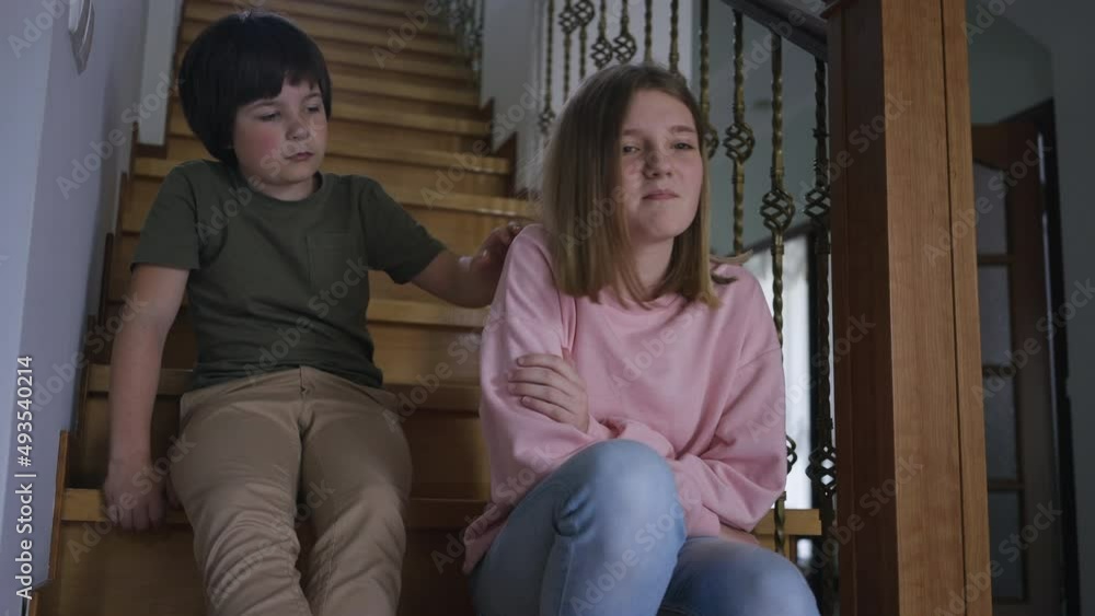 Irritated teenage girl pushing away hand of little boy leaving as ...